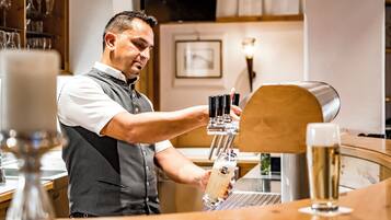Um barman servindo uma bebida de uma torneira.