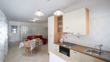 Um frigorífico, uma placa de cozinha, uma cafeteira/bule