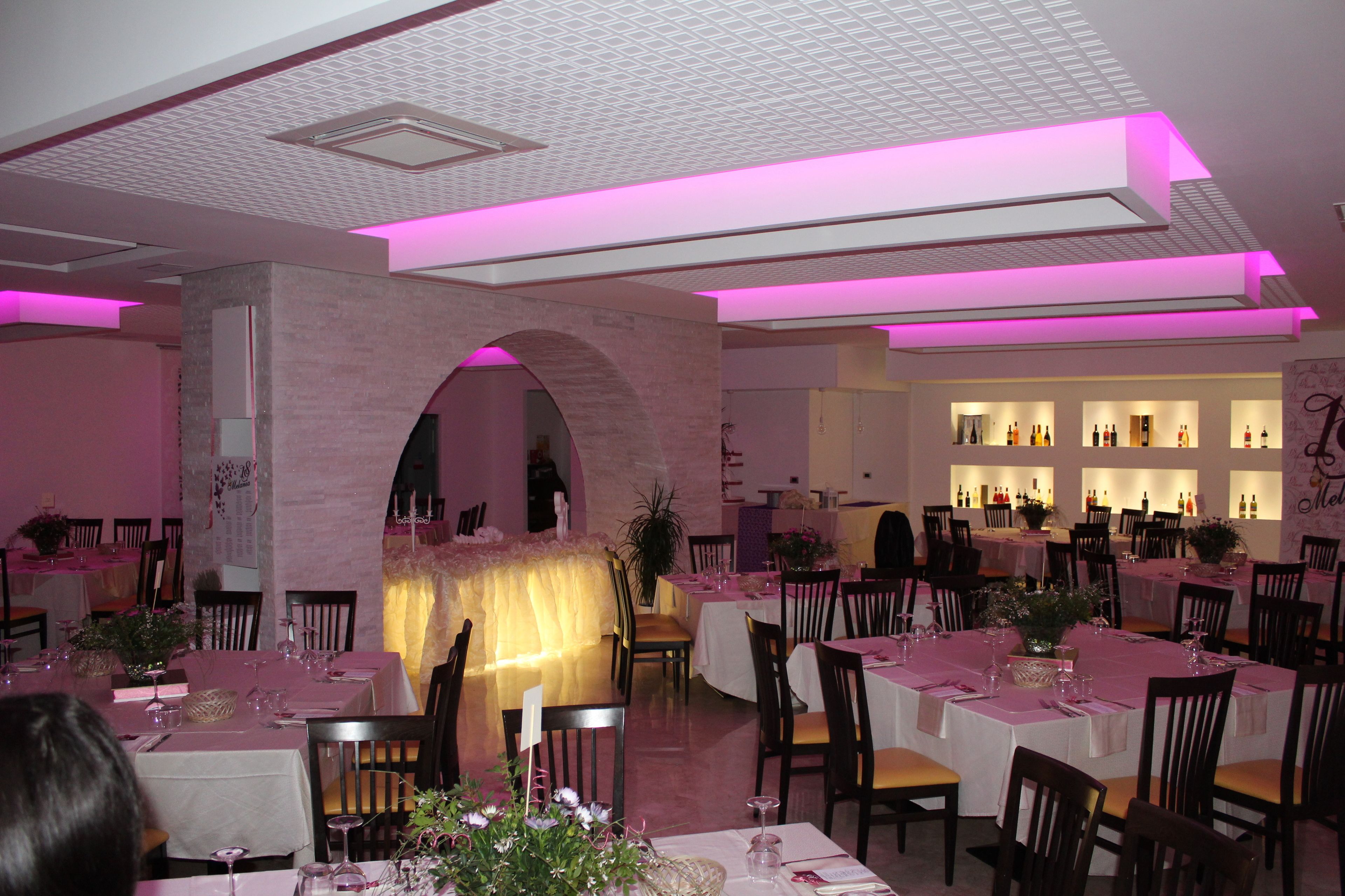 Um restaurante com várias mesas, cadeiras e um balcão de bar.