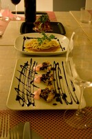 Uma mesa de jantar com dois pratos de comida, um com massa e outro com sobremesa.