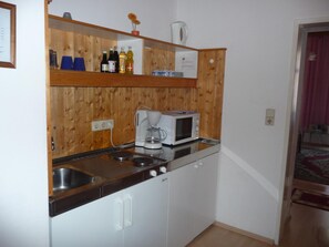 Um frigorífico, uma máquina de café expresso, uma cafeteira/bule 
