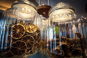 Três potes de vidro com fatias de cítricos secas, colocados sobre uma mesa.