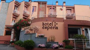 Um hotel chamado 'hotel esperia', com design arquitetônico moderno, com varandas e área de jardim ajardinada.