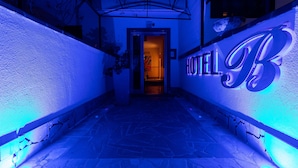 Um corredor que leva à entrada de um hotel, com uma placa indicando "HOTEL B".