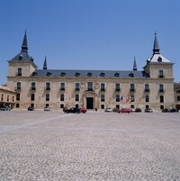 Um grande edifício histórico com várias torres e um pátio.