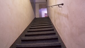 Uma escada com corrimão e uma porta no topo.