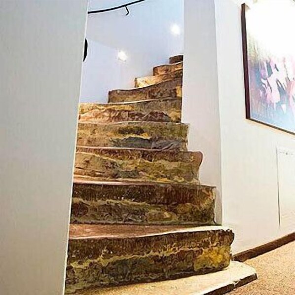 Uma escadaria com degraus de pedra que levam a um andar superior.