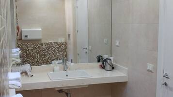 Uma casa de banho moderna com um espelho grande, lavatório e porta-toalhas.