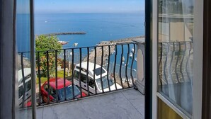 Uma varanda com vista para o mar e barcos.
