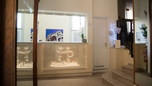 Balcão de recepção de hotel com uma placa indicando 'Hotel Palladio'.