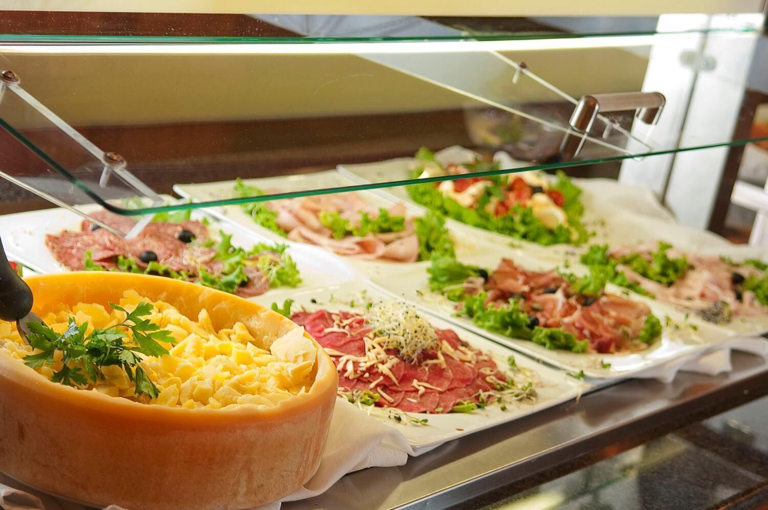 Buffet com diversos pratos, incluindo massas, saladas e carnes.