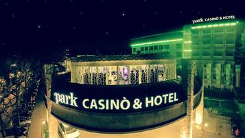 Vista noturna do Park Casino & Hotel, com um letreiro iluminado em destaque e estrutura de edifício moderna.