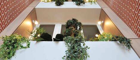 Um átrio em vários níveis com vegetação e iluminação.