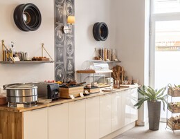 Uma bancada de cozinha com uma cafeteira, uma panela e diversos alimentos.