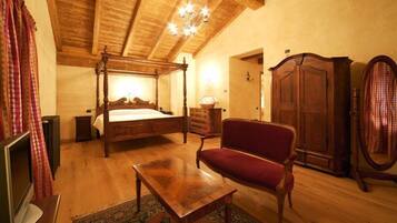 Um quarto tradicional com uma cama de dossel, um guarda-roupa de madeira, uma poltrona estofada vermelha e uma mesa de madeira.