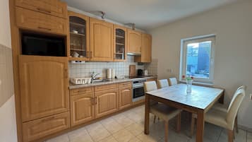 Apartamento, 3 quartos, cozinha | Cozinha privada | Um frigorífico, um micro-ondas, uma placa de cozinha