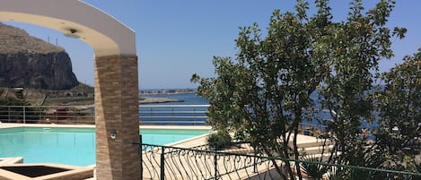 Uma área de piscina com vista para o mar e uma montanha.