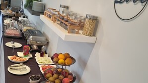 Disposição de buffet com diversos alimentos e bebidas.