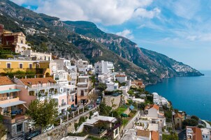 Uma cidade costeira com edifícios ao longo de uma encosta, com vista para o mar.