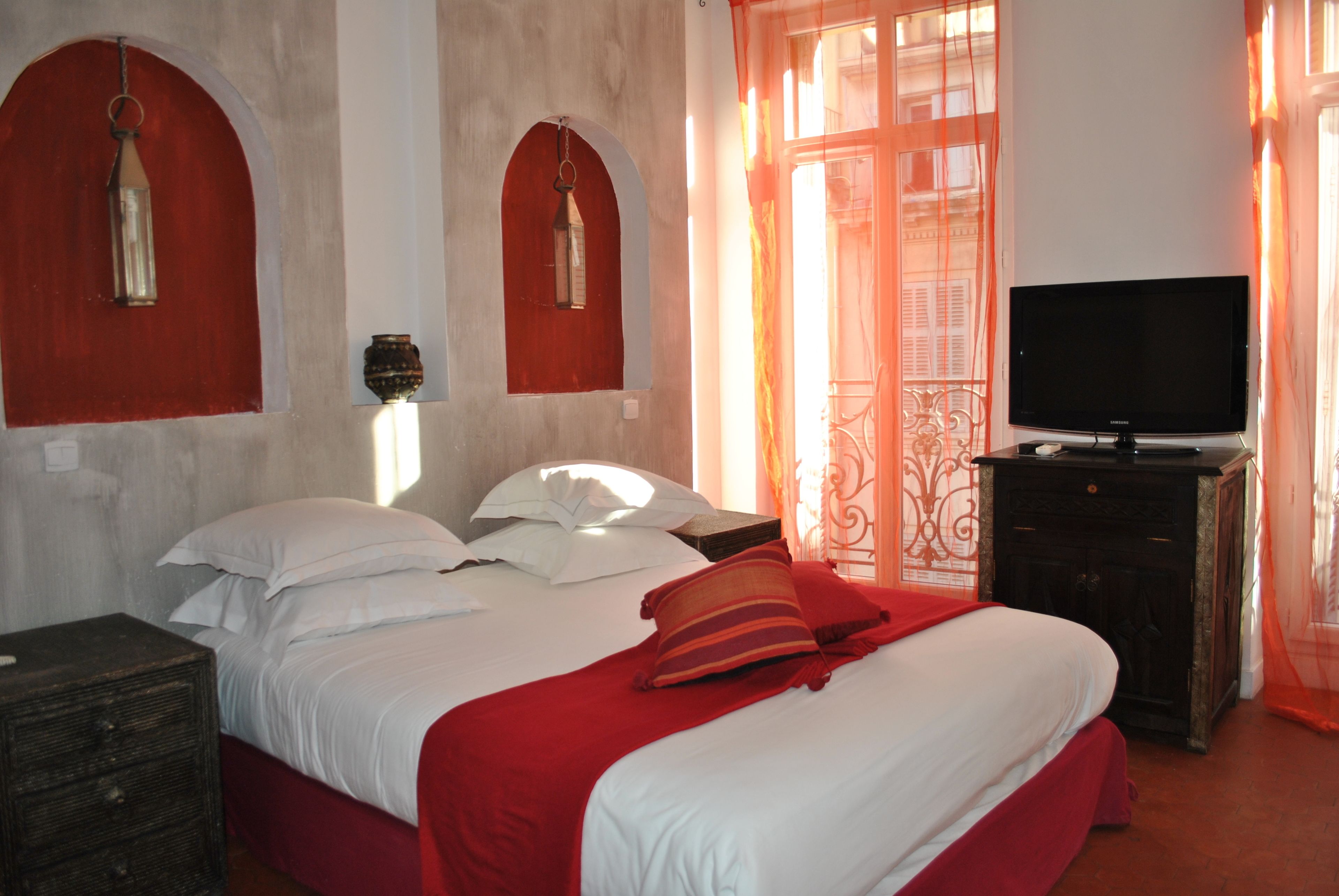 Quarto com cama, televisão e penteadeira.