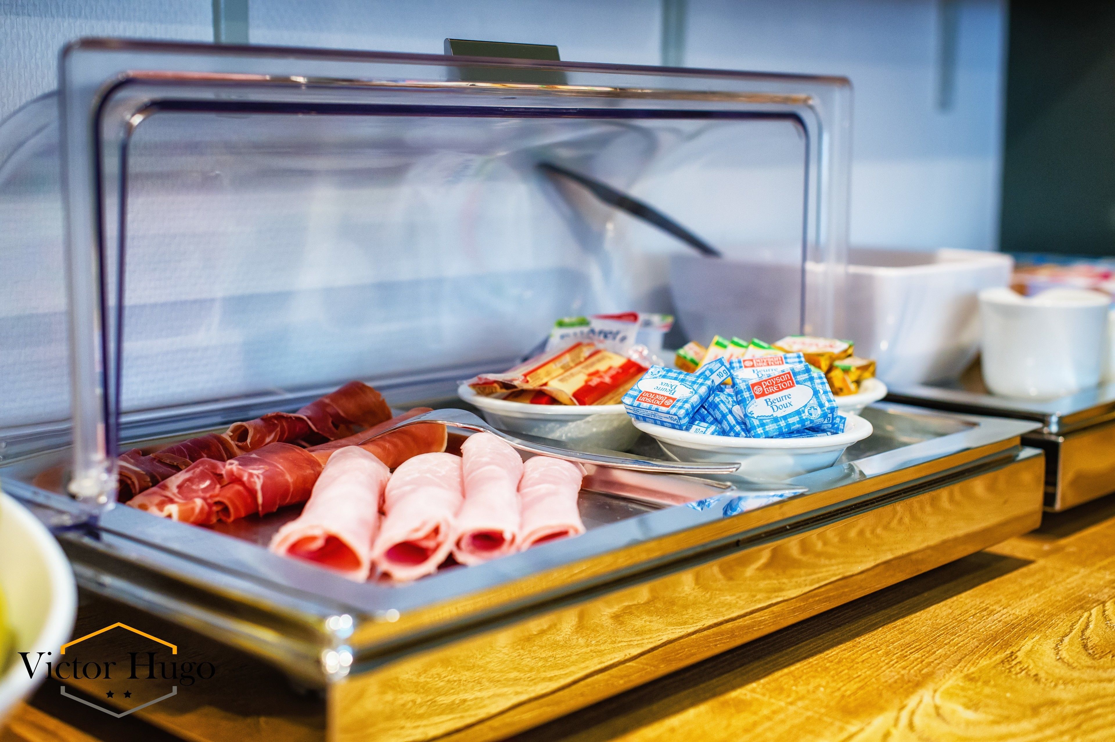Buffet com diversos itens de comida, incluindo carnes, queijos e salgadinhos industrializados.