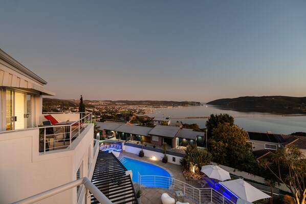 Um imóvel residencial com piscina, área de estar externa e vista para o mar.