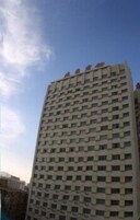 Um edifício alto com fachada em grade e várias janelas.