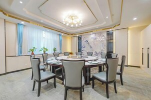 Uma sala de conferências com uma mesa redonda, cadeiras e um candelabro.