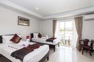 Quarto de hotel com duas camas, uma mesa de jantar e uma cadeira.