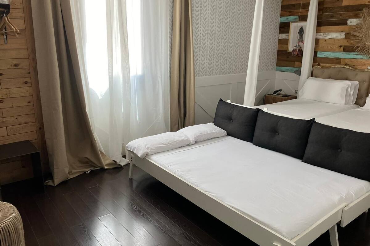 Quarto com uma cama, uma mesa de cabeceira e um espelho na parede.