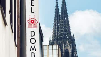 Placa de hotel com uma torre gótica ao fundo.