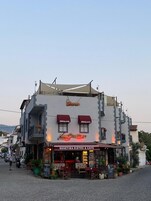 Um edifício com uma placa indicando 'Rebeka Bistro & Cafe' e 'Rebeka Hotel' na fachada.