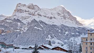 Um resort na montanha, com edifícios cobertos de neve e um pico imponente ao fundo.