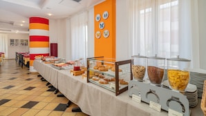 Disposição de buffet com diversos alimentos e um pilar decorativo.