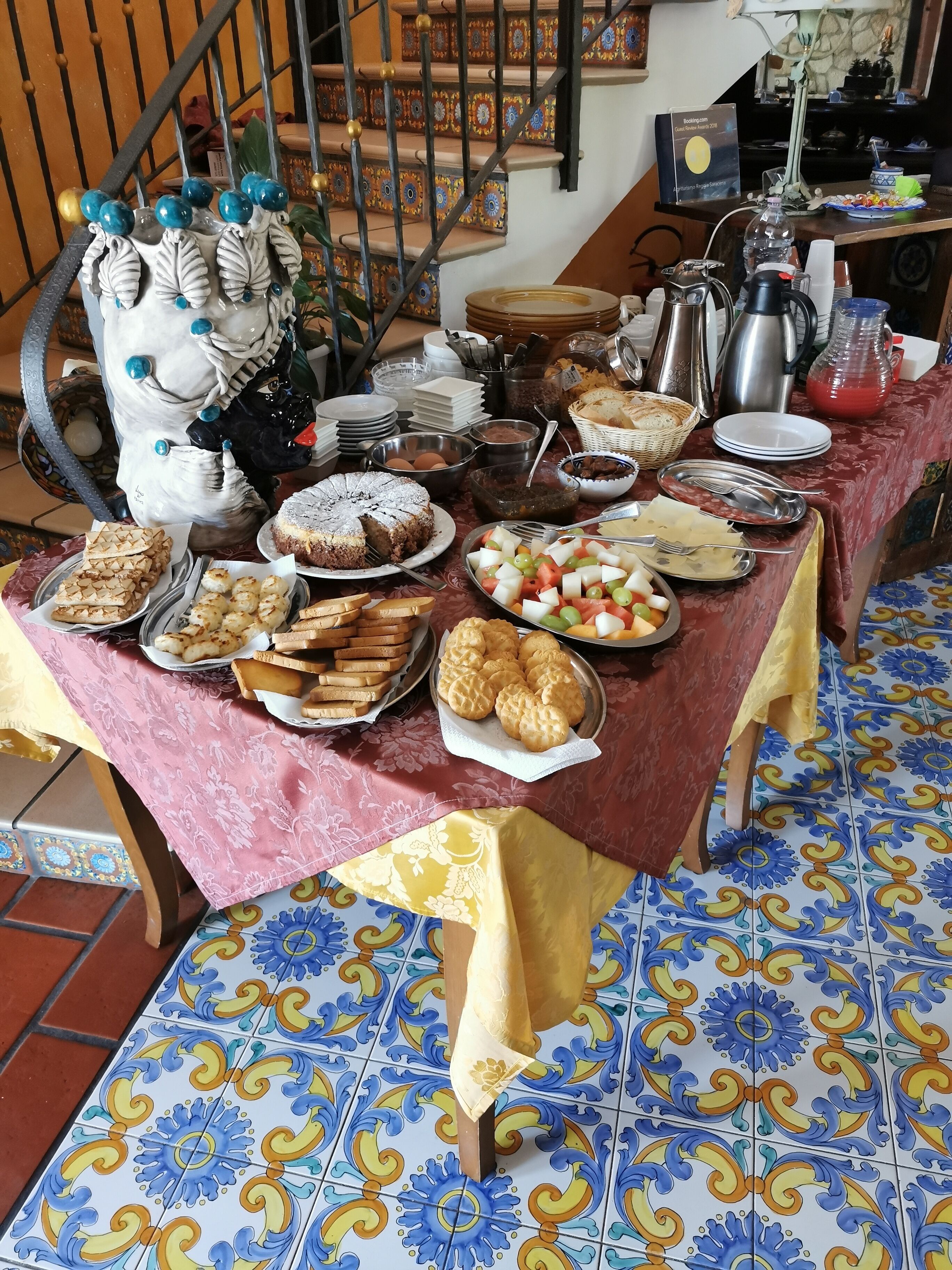 Um buffet de café da manhã com diversos alimentos e um vaso decorativo.