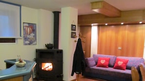 Uma sala de estar com lareira, um sofá e uma poltrona.