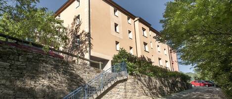 Um edifício de vários andares com uma escadaria de pedra que leva a um corrimão de metal.