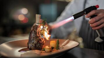 Um chef preparando um bife com um maçarico.