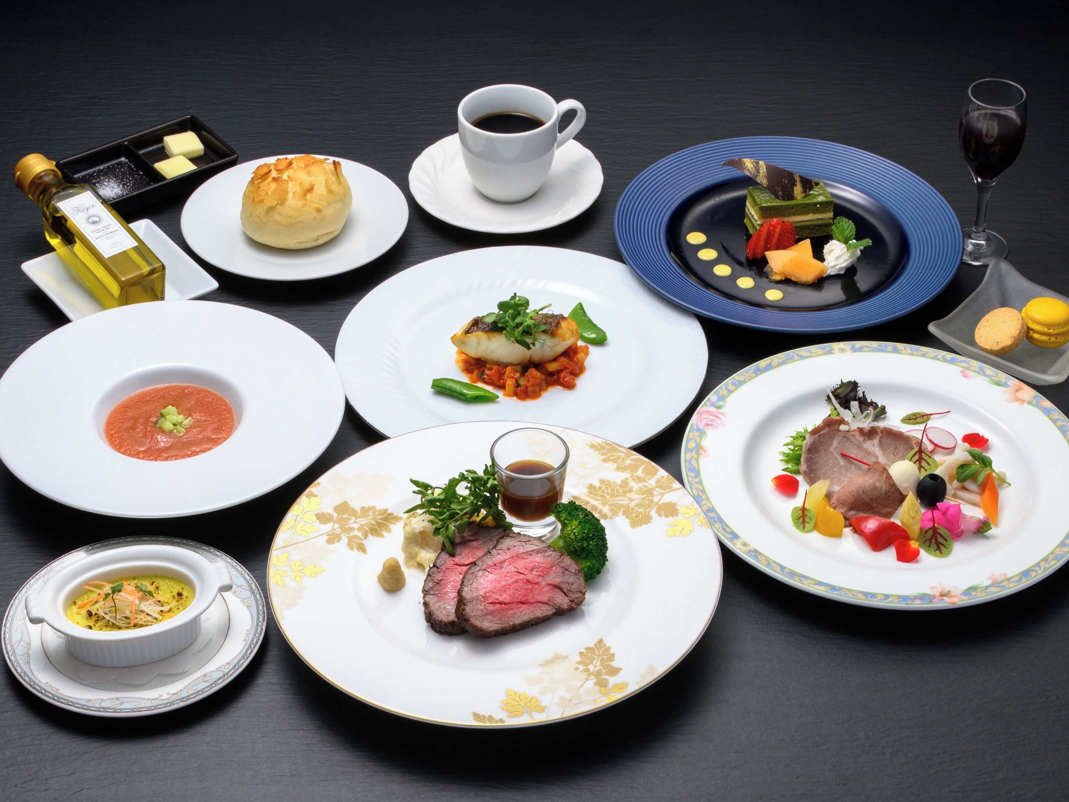 Diversos pratos em chapas, incluindo sopa, bife e sobremesa.