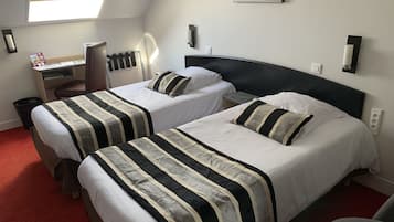 Quarto duplo com duas camas, uma escrivaninha e uma cadeira.