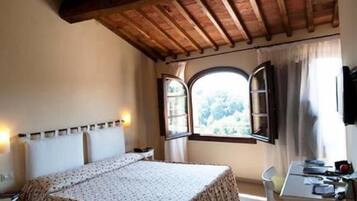 Um quarto com uma cama, uma escrivaninha e uma janela com cortinas.