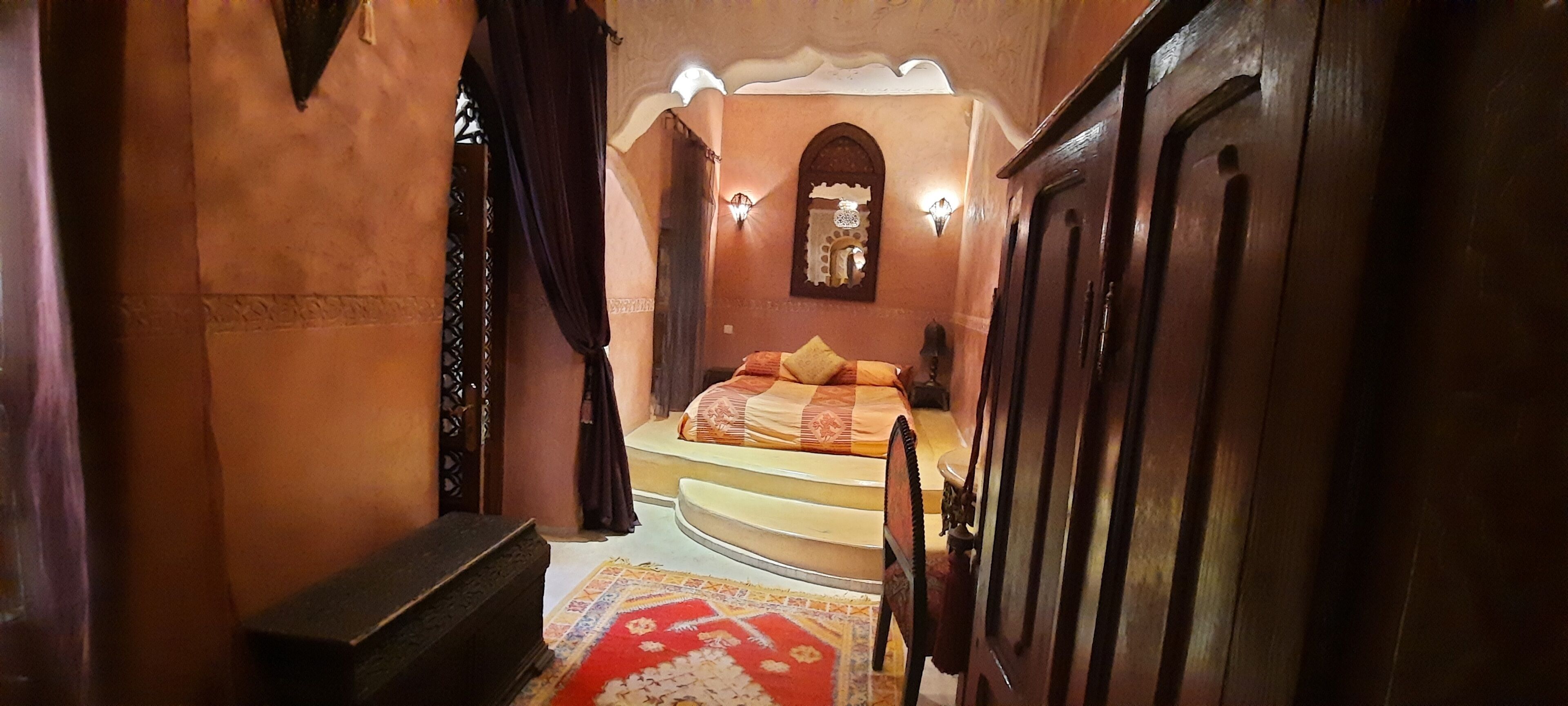 Um quarto com uma cama, escada e porta.