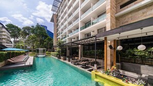 Hotel com piscina, área de estar externa e vista para uma montanha.