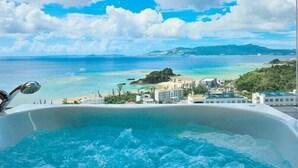 Uma banheira de hidromassagem com vista para a praia e edifícios.