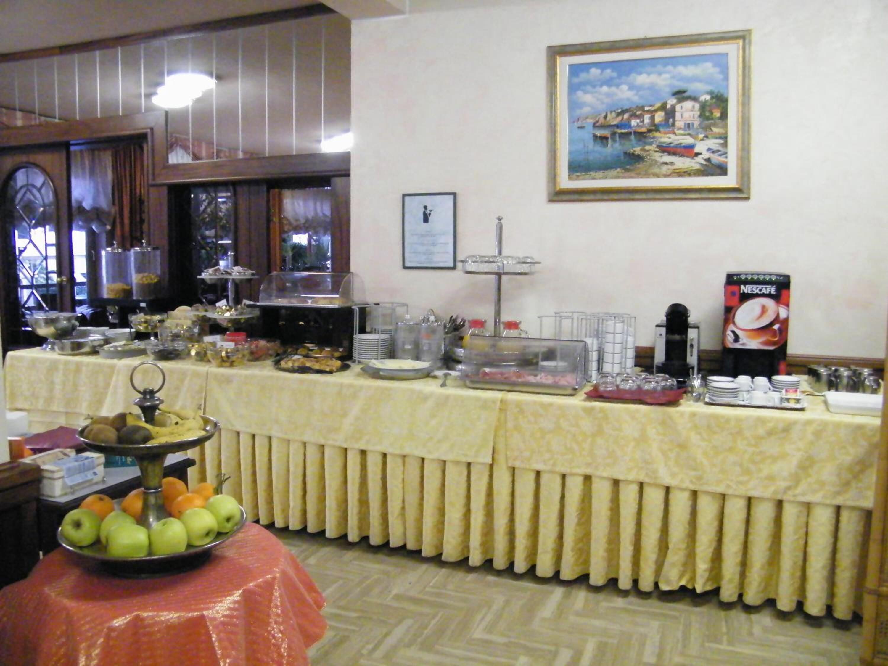 Disposição de buffet com diversos alimentos e um canto para café.