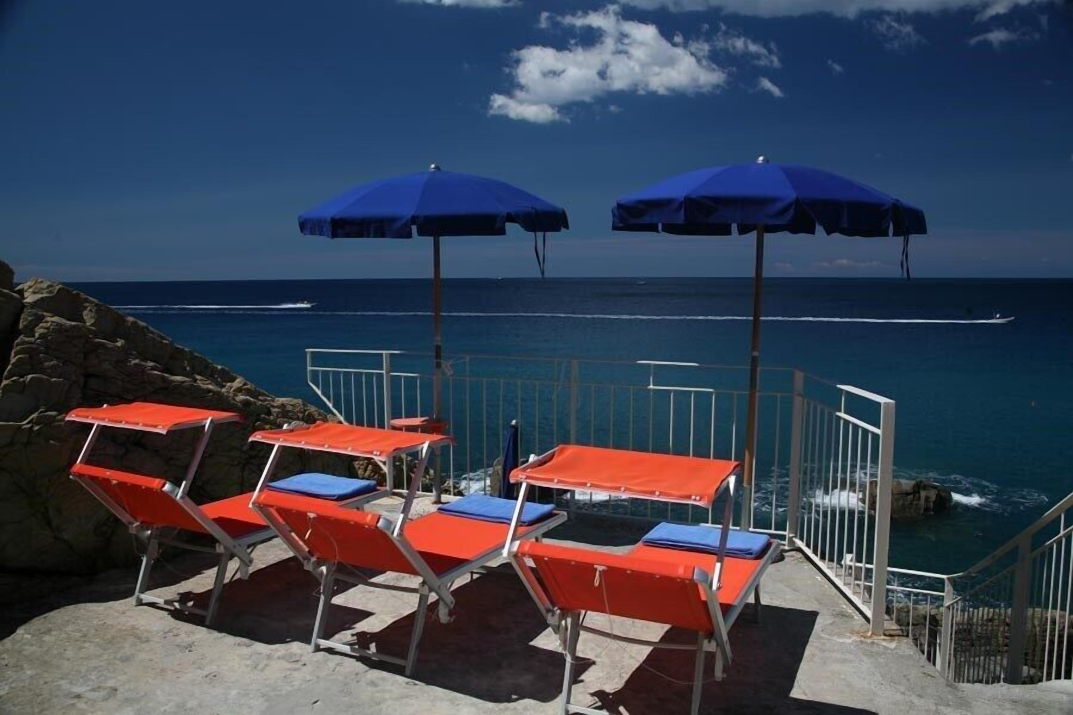 Uma praia privada, espreguiçadeiras, guarda-sóis de praia 