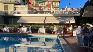 Área na piscina com assentos ao ar livre e vista dos edifícios ao redor.