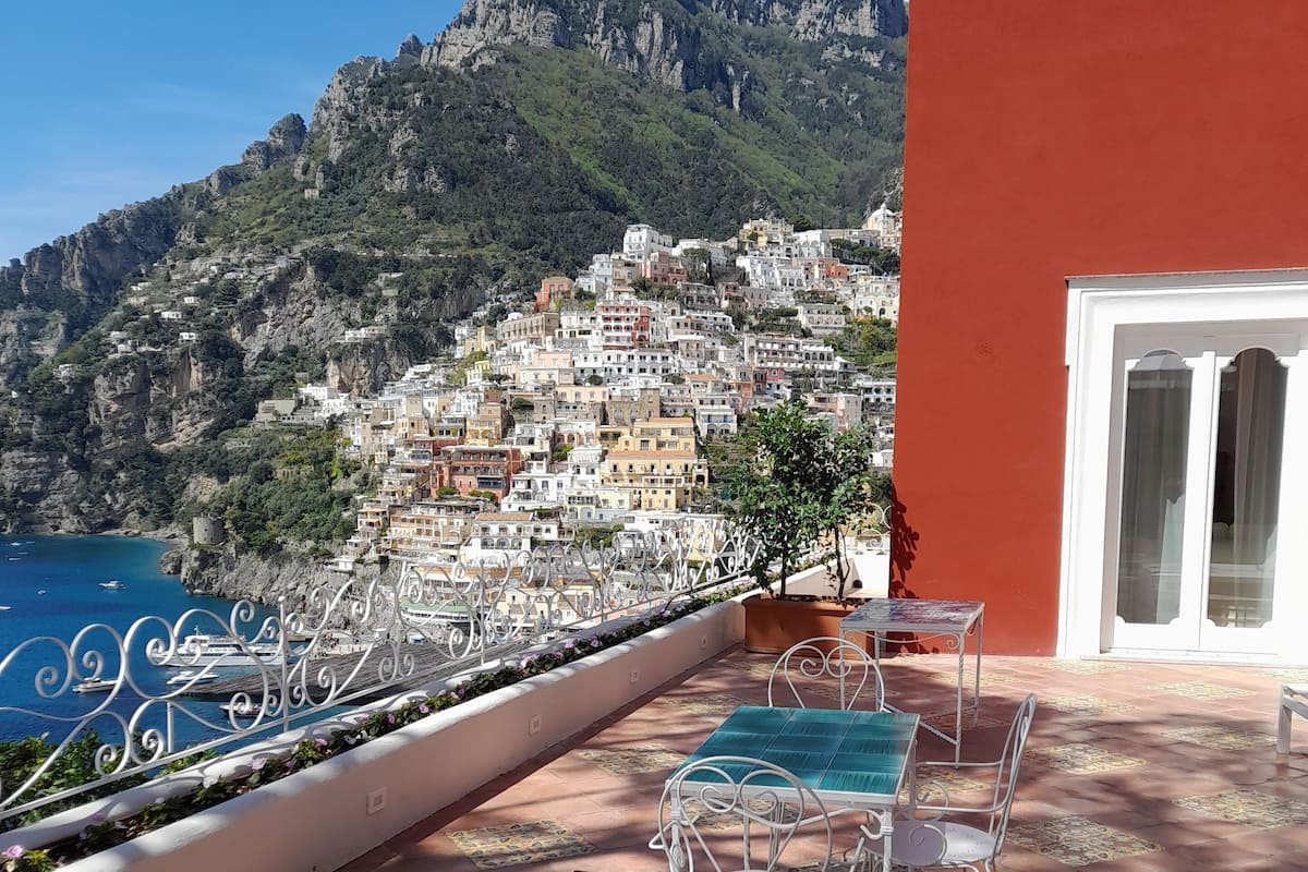 Terraço com área de estar ao ar livre e vista para uma cidade costeira.