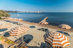 Praia particular, espreguiçadeiras, guarda-sóis 