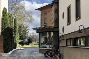 Um edifício com entrada curva, suporte para bicicletas na parte externa e placa indicando um spa.